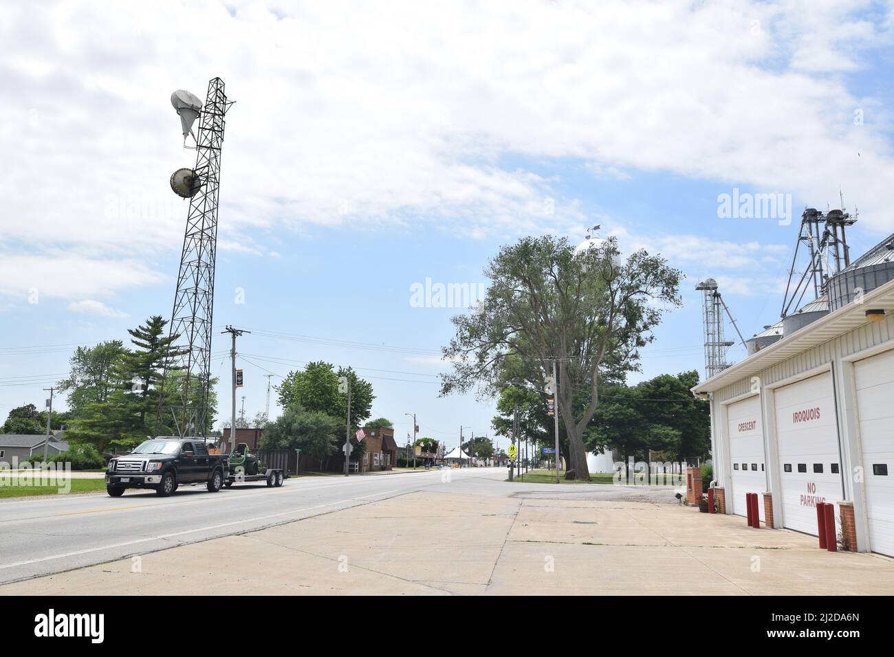 Pick up truck hauling a riding mower heading east through the town of ...