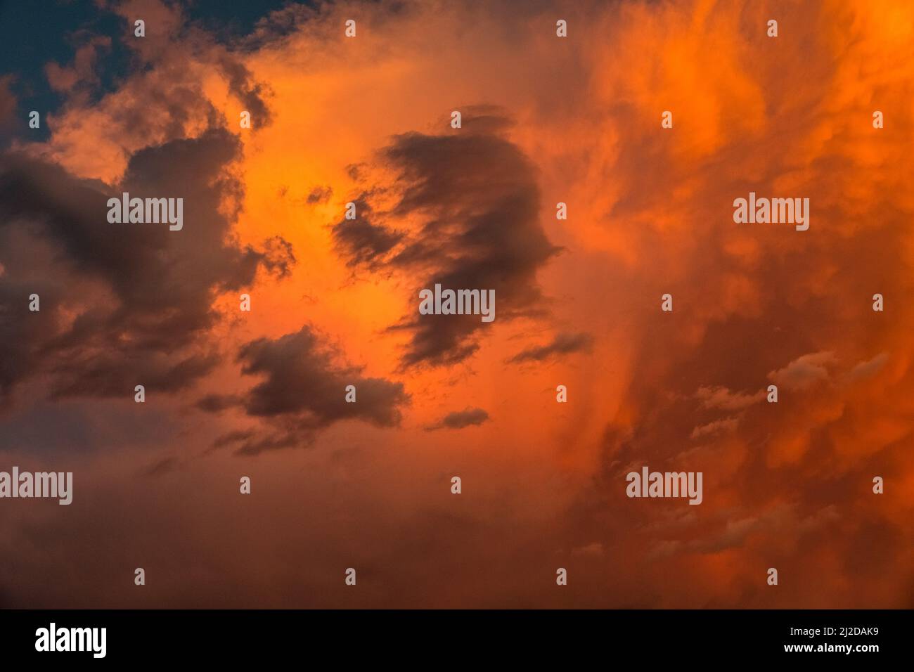 A breathtaking landscape view of orange dramatic clouds of dusk sky at ...