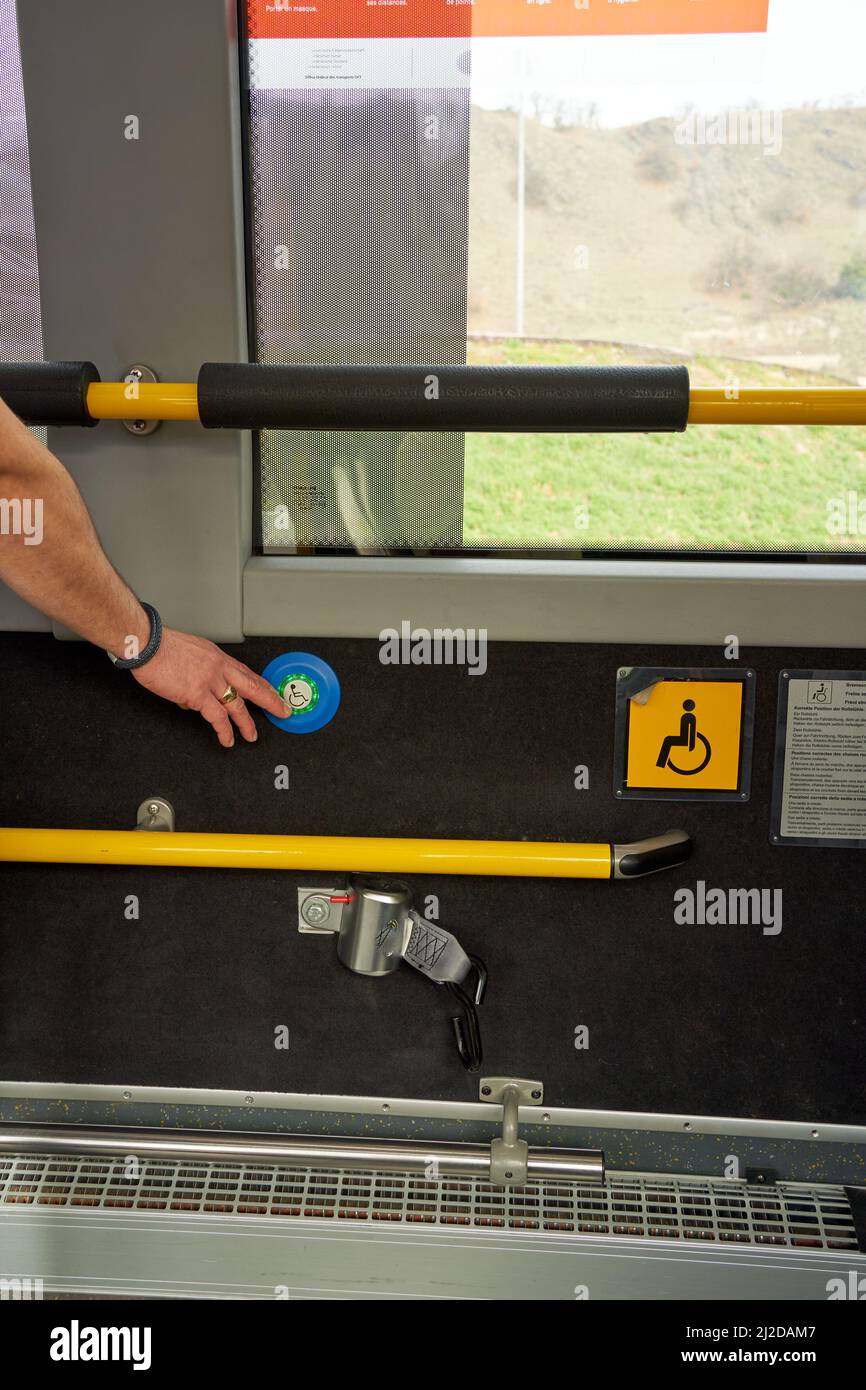 An adult man hand pushing the blue button of the disabled people door ...