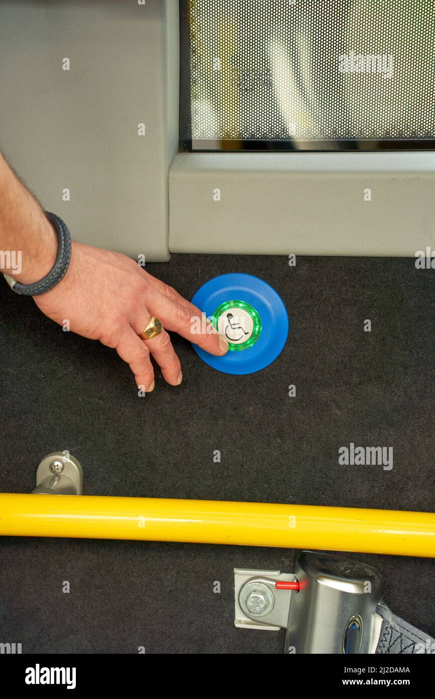 An adult man hand pushing the blue button of the disabled people door ...