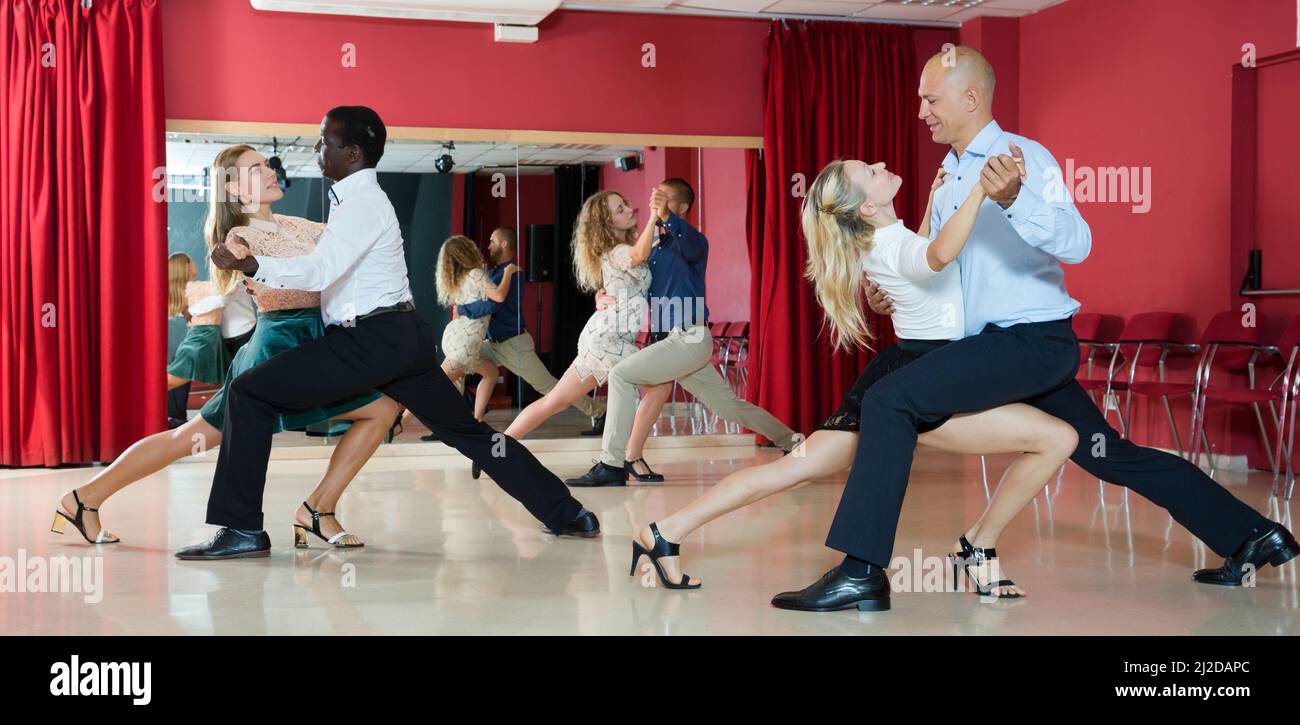 Adult pairs dancing tango movements in modern dance studio Stock Photo ...