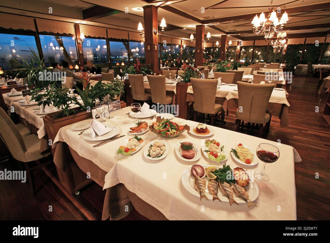 Grilled bluefish (Turkish: Cinekop-Lufer) with appetizer foods and red ...