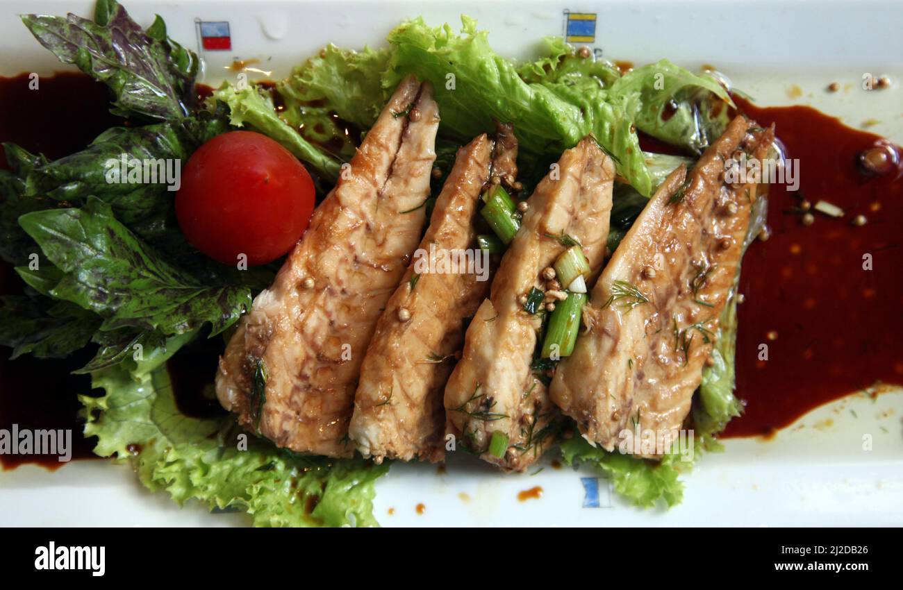Bonito fish with sauce and vegetables on the dinner plate Stock Photo ...