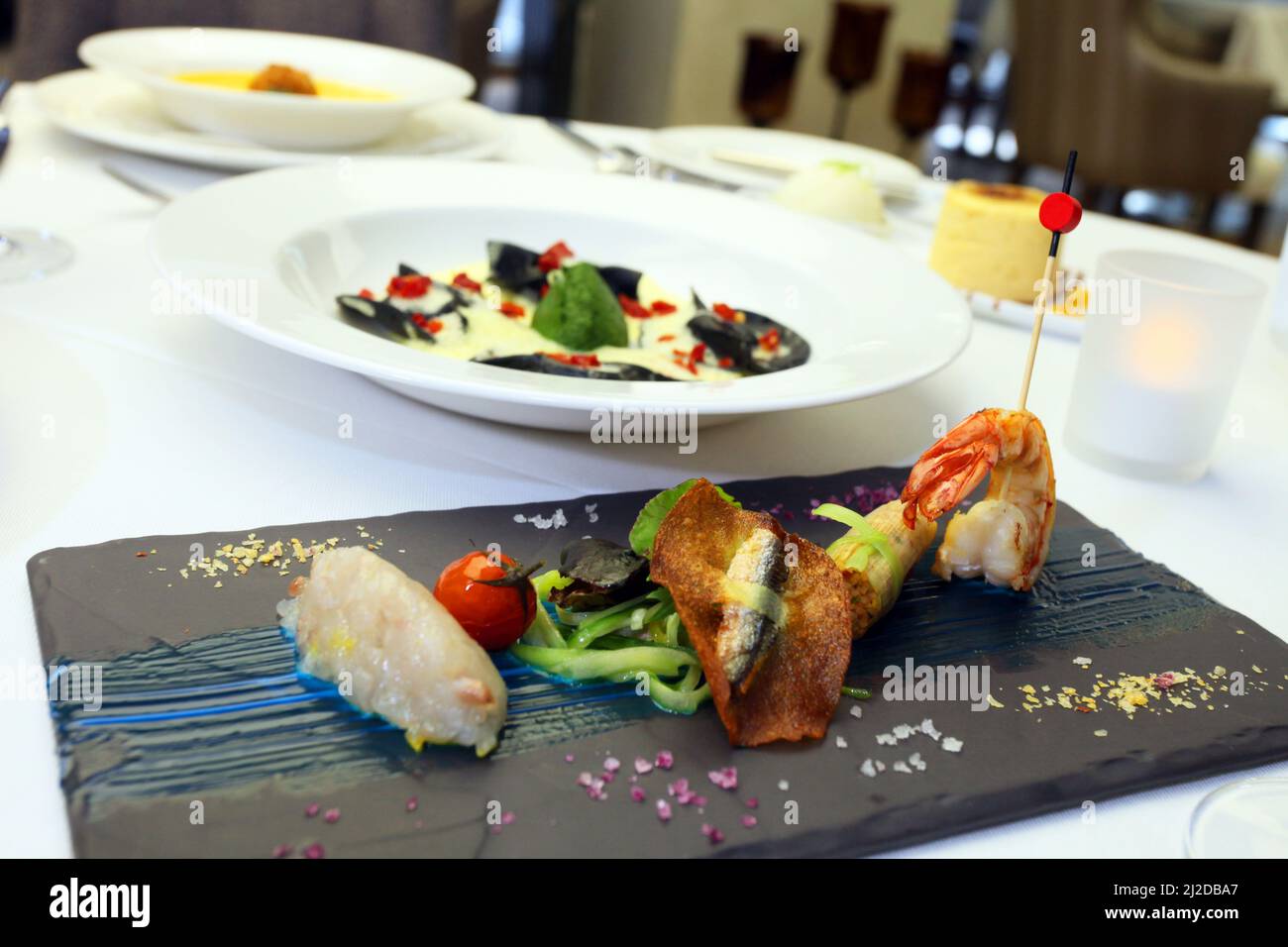 Mixed seafood platter behind Black Squid Ink Ravioli on the restaurant ...