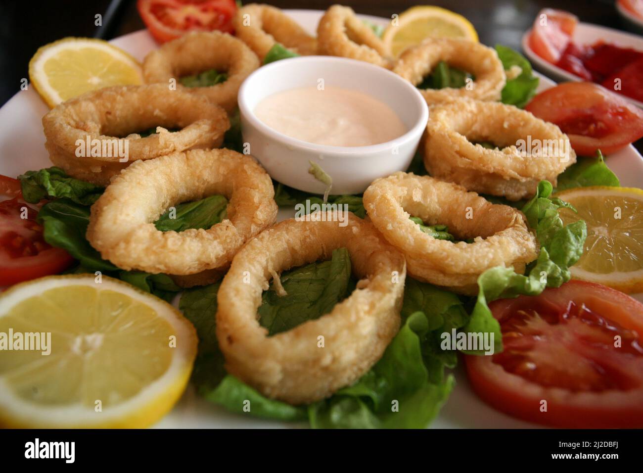 Squid rings with sauce on the dinner plate Stock Photo - Alamy