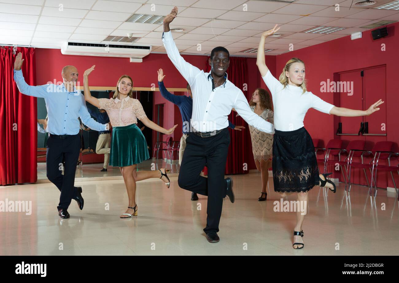 Young people practicing twist movements together at modern dance studio ...
