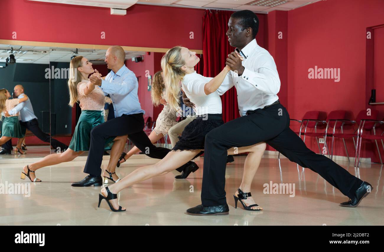 Adult pairs dancing tango movements in modern dance studio Stock Photo ...