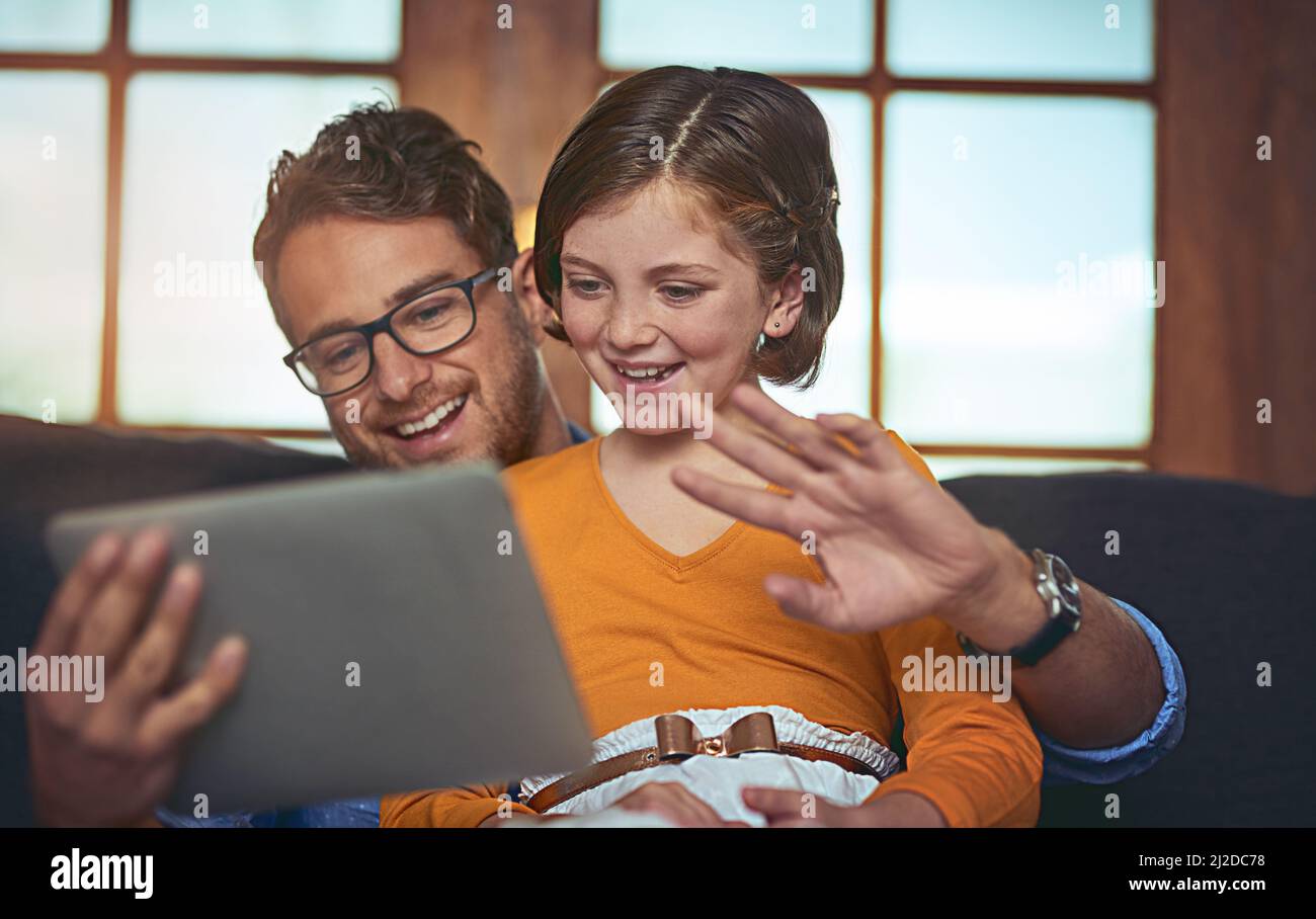 Saying hello to family around the world. Shot of a father and daughter ...