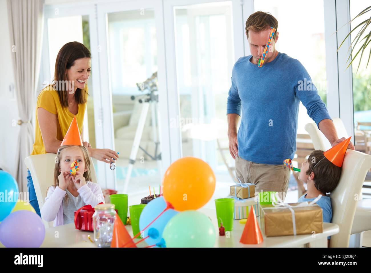 Birthday party fun in full swing. Shot of a happy family playing with ...