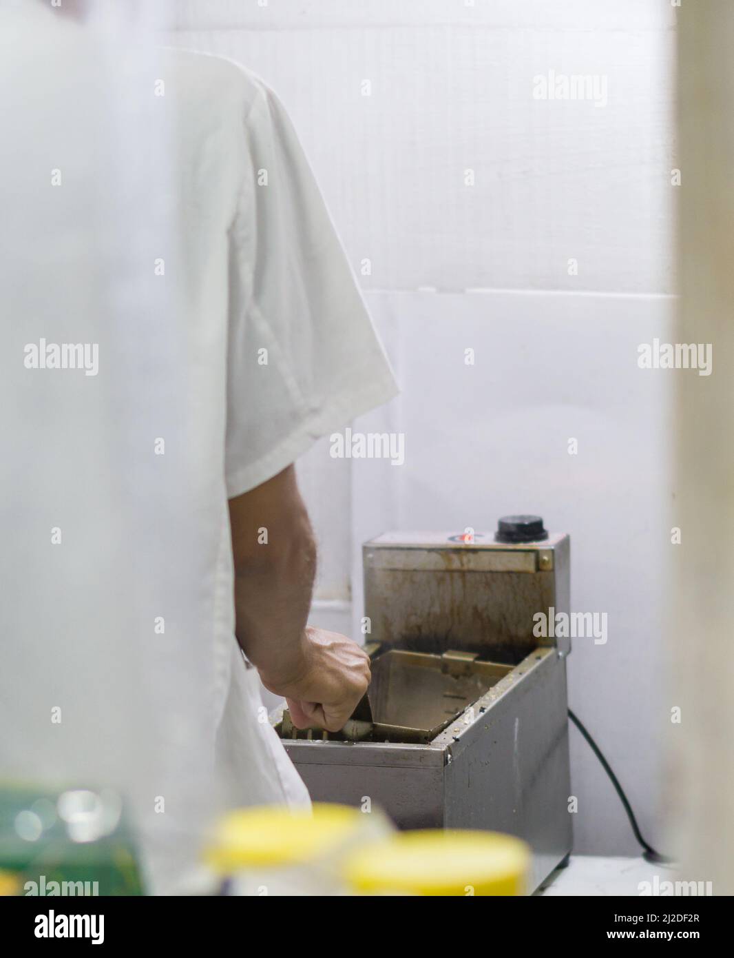 Man working frying food, unrecognizable person Stock Photo - Alamy