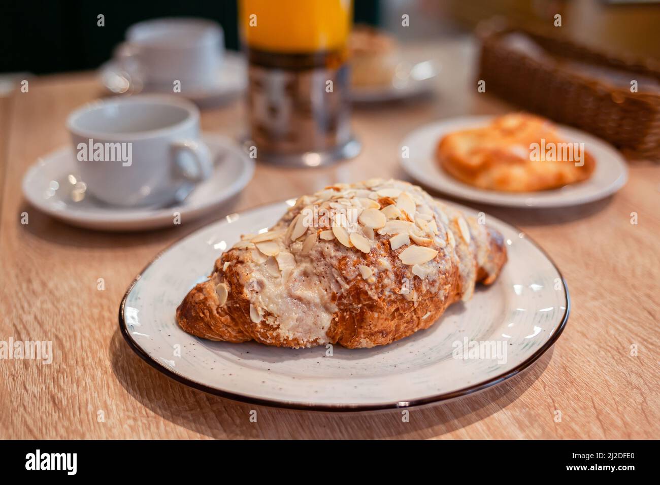 A fresh large croissant on a beautiful plate in a cafe or restaurant ...