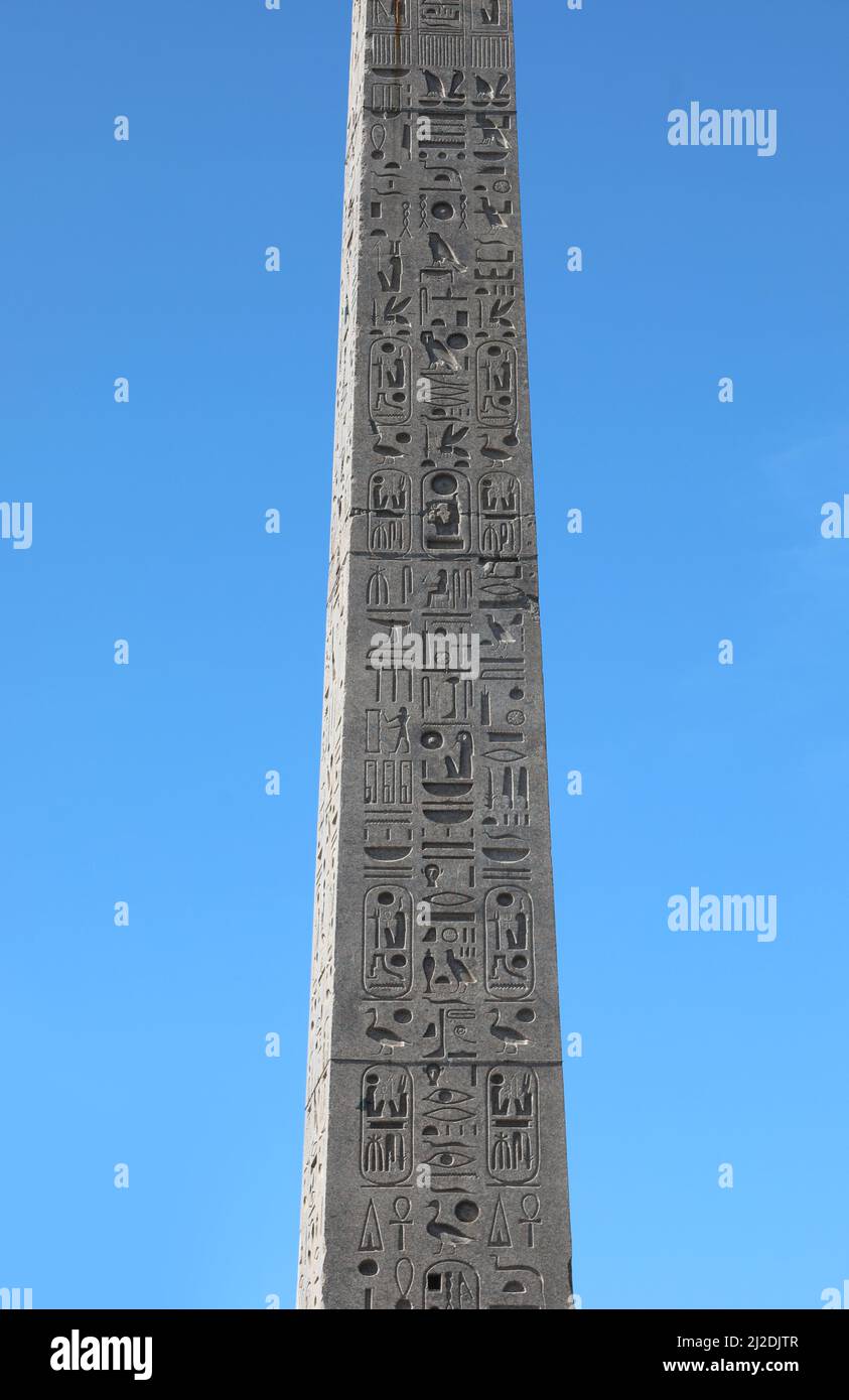 ancient Egyptian obelisk with engraved hieroglyphs on blue sky ...