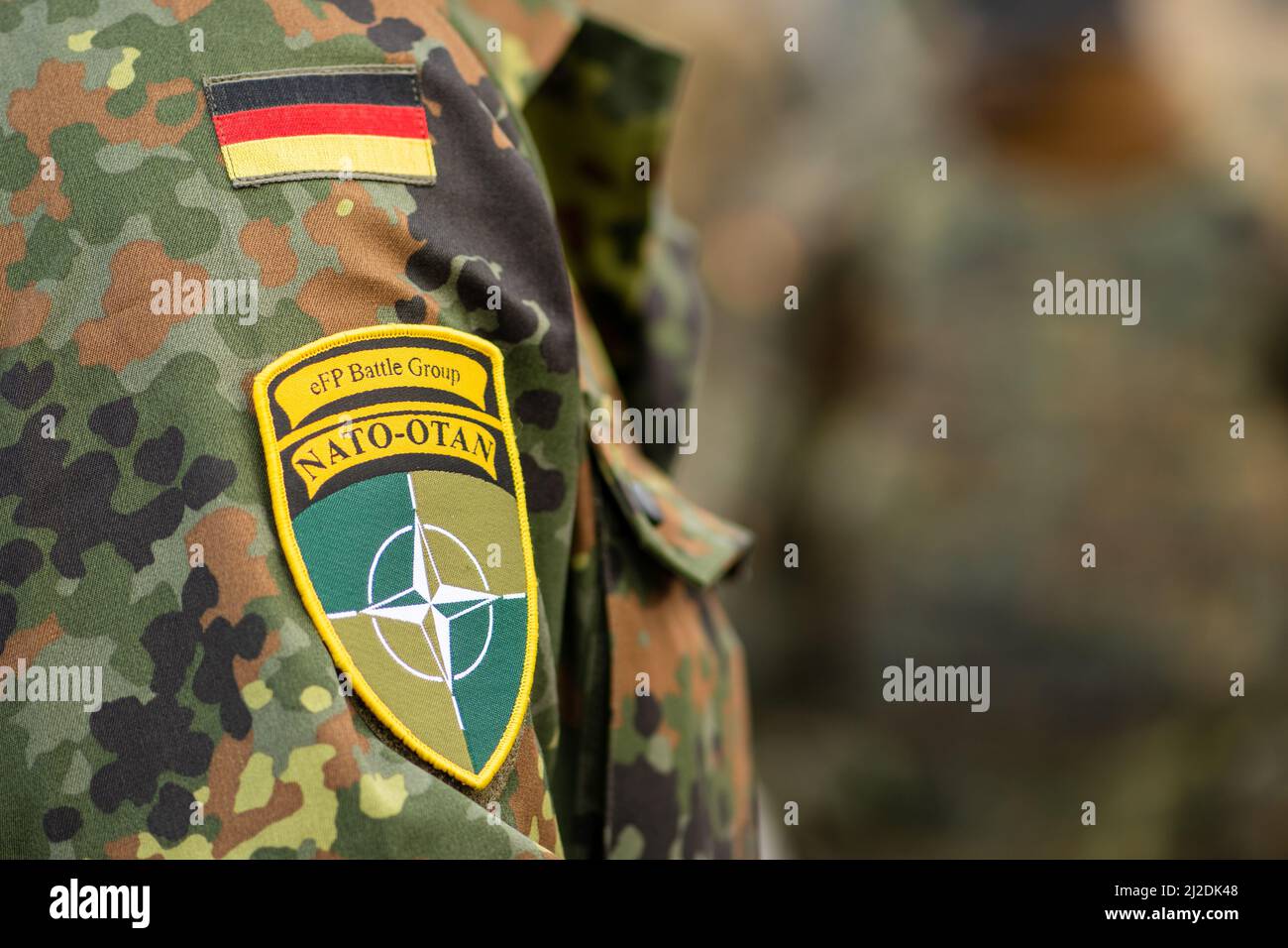 Flag of Germany and symbol of NATO battle group on a soldier uniform ...