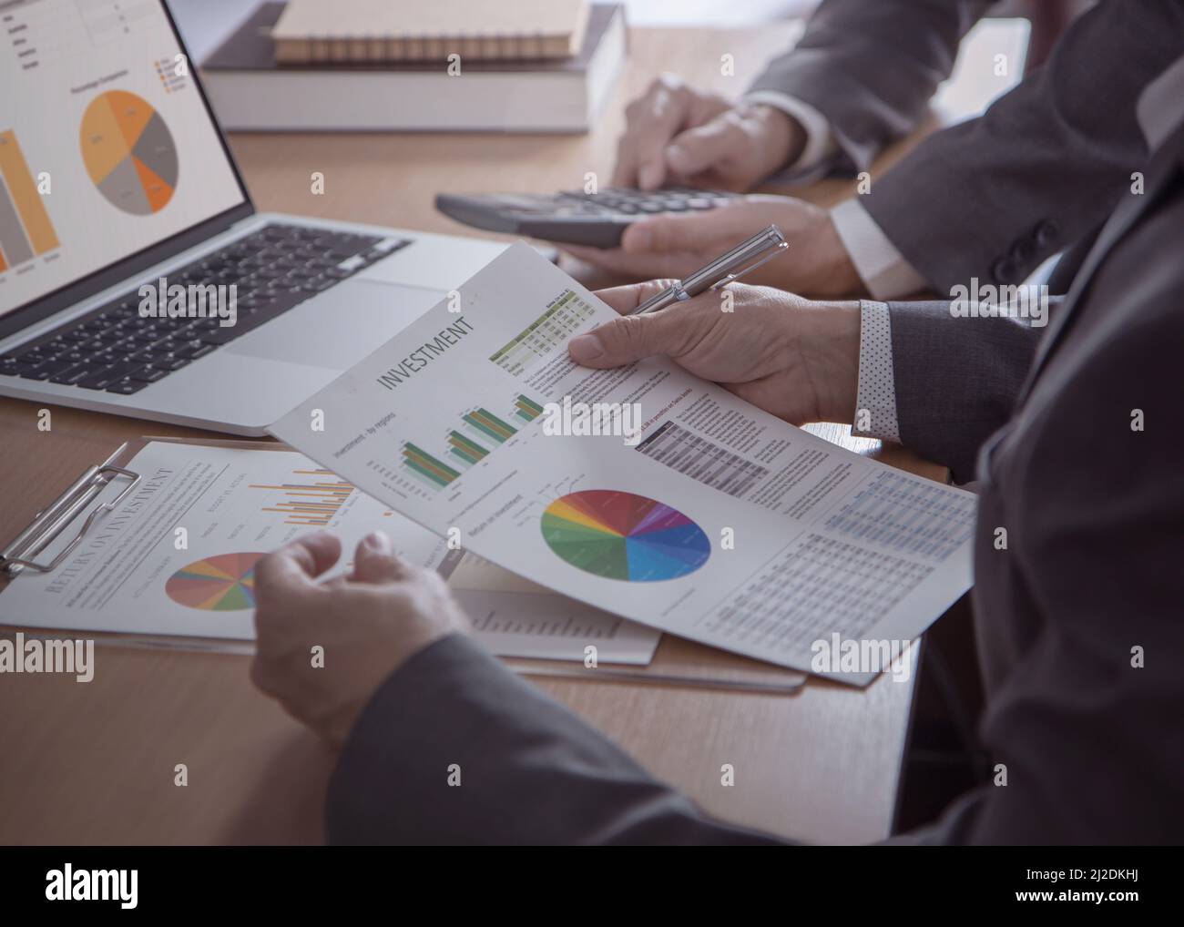 Two businessmen with laptop computer and calculator review financial ...