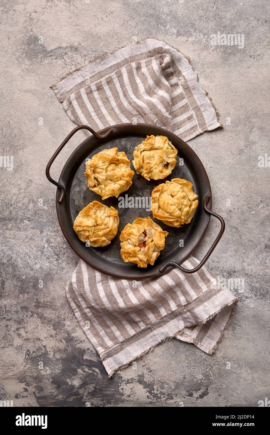 Vertical orientation cherry cakes from filo dough on metal tray with ...