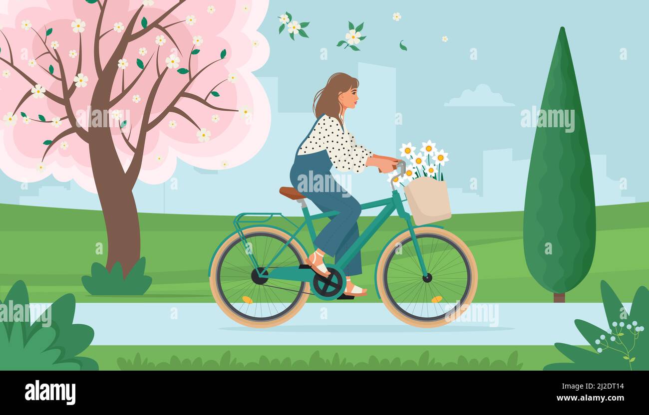 Woman riding bike with flowers in the basket, in the park, on Spring ...