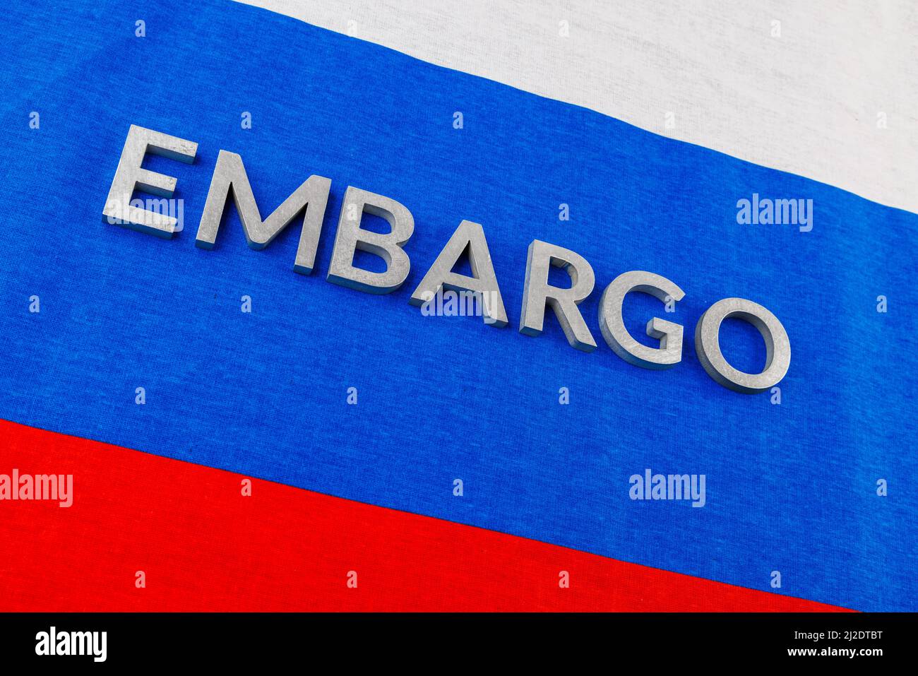 the word embargo laid with silver metal letters on russian tricolor ...