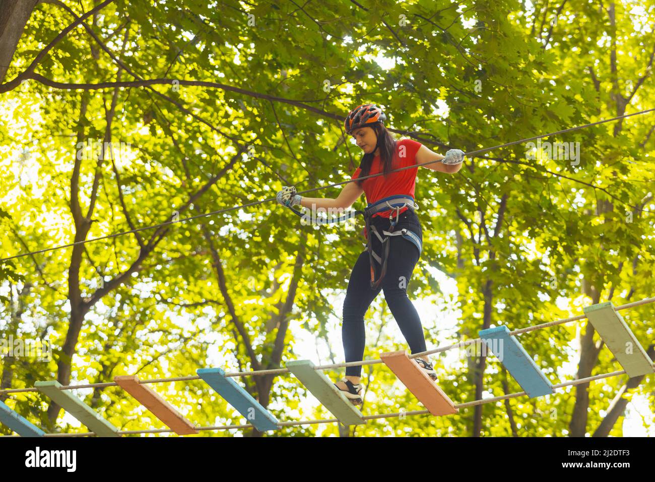 The woman is doing exercise in the adventure rope park Stock Photo - Alamy