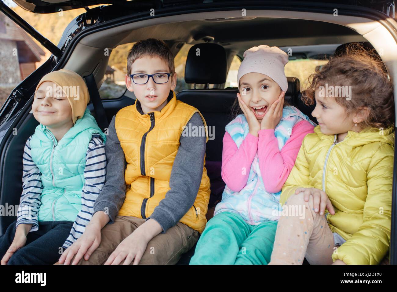 Mom and little boy sitting in hatchback car with mountain background ...