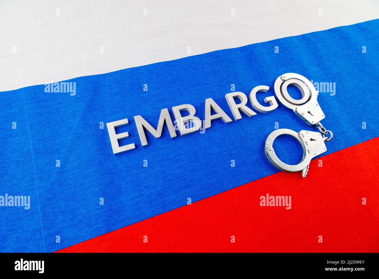 the word embargo laid with silver metal letters on russian tricolor ...