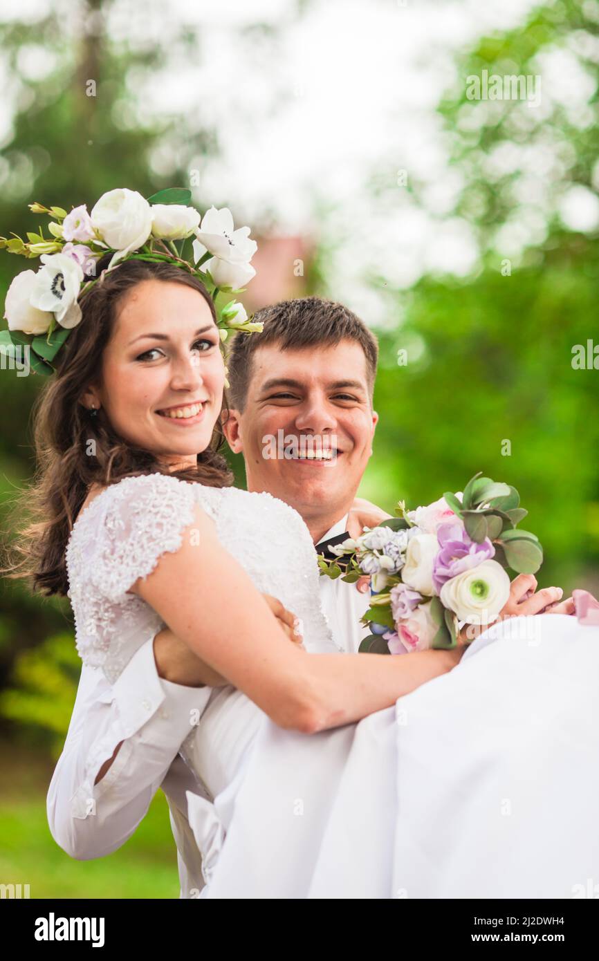 Happy wedding day. Groom holding the bride Stock Photo - Alamy