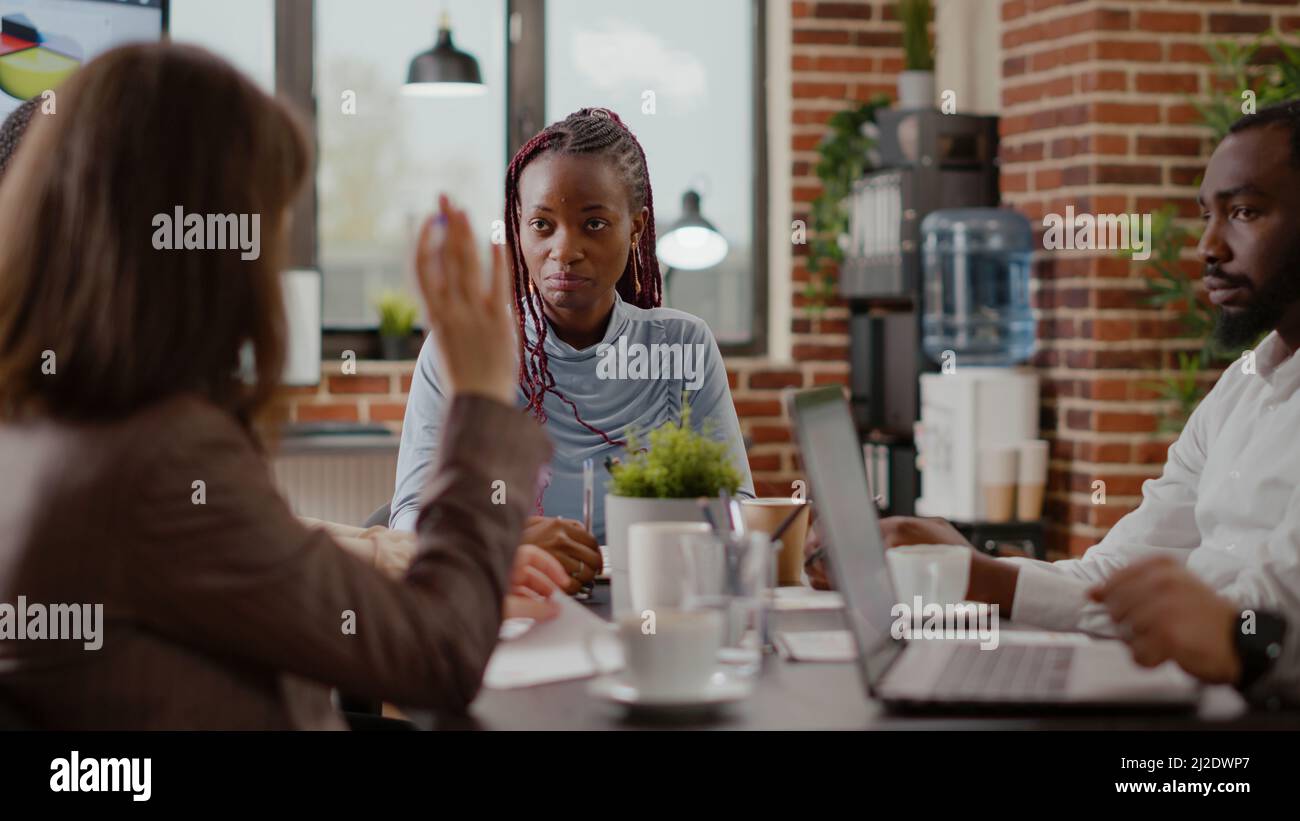 Close up of employee talking to colleagues about business project ...