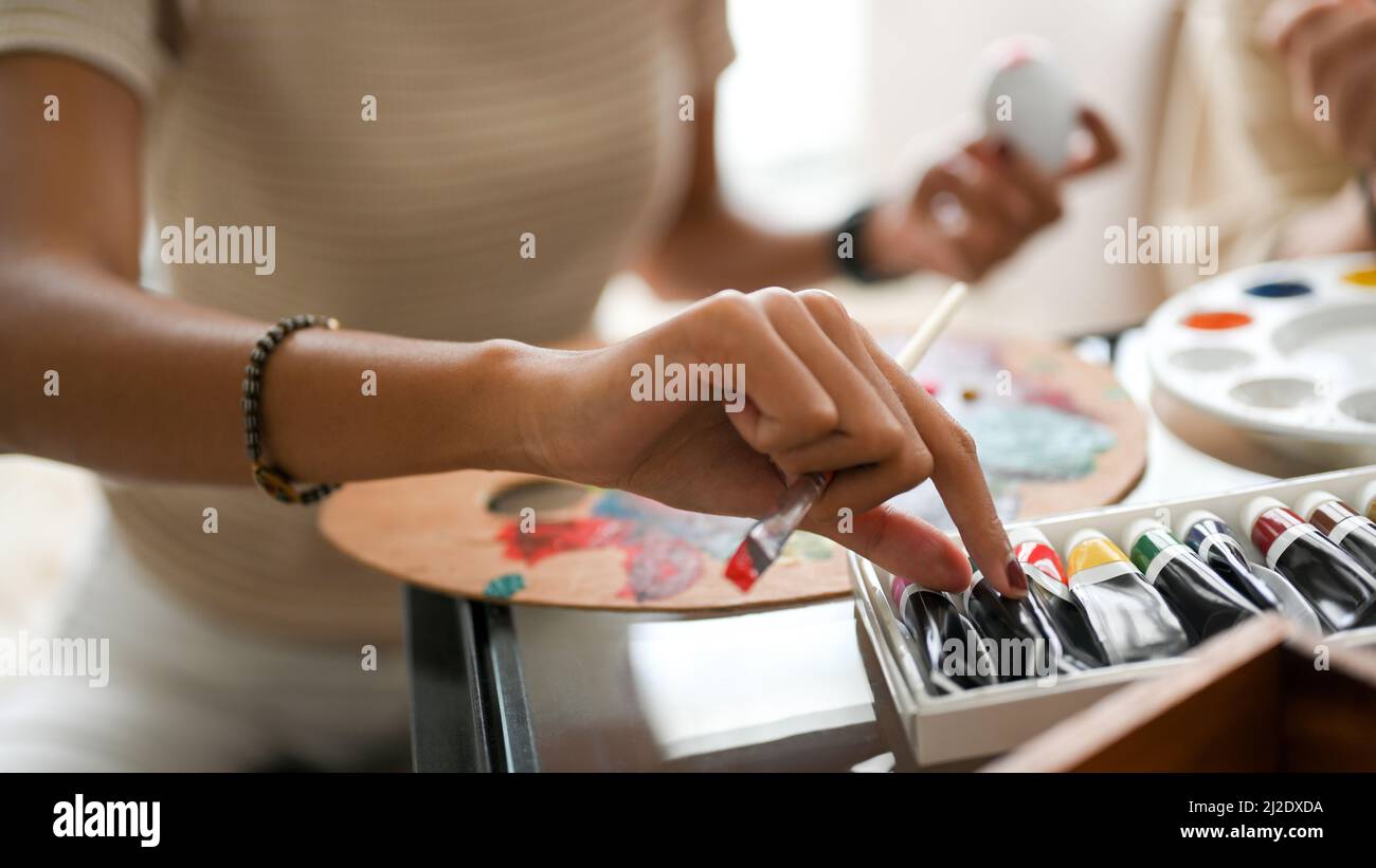 Close-up hands, Female grabbing an acrylic colour tube, choosing a ...