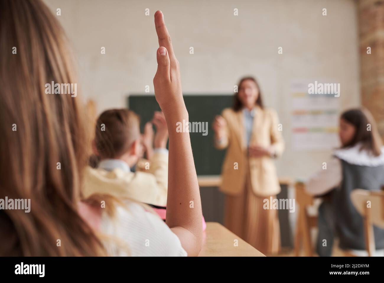 Female student raised hand desk hi-res stock photography and images - Alamy