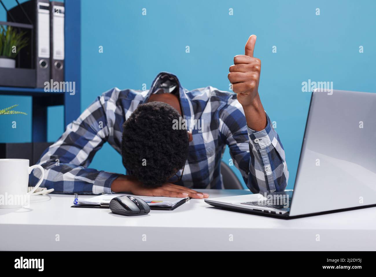 Exhausted young adult businessman falling asleep on desk while showing ...