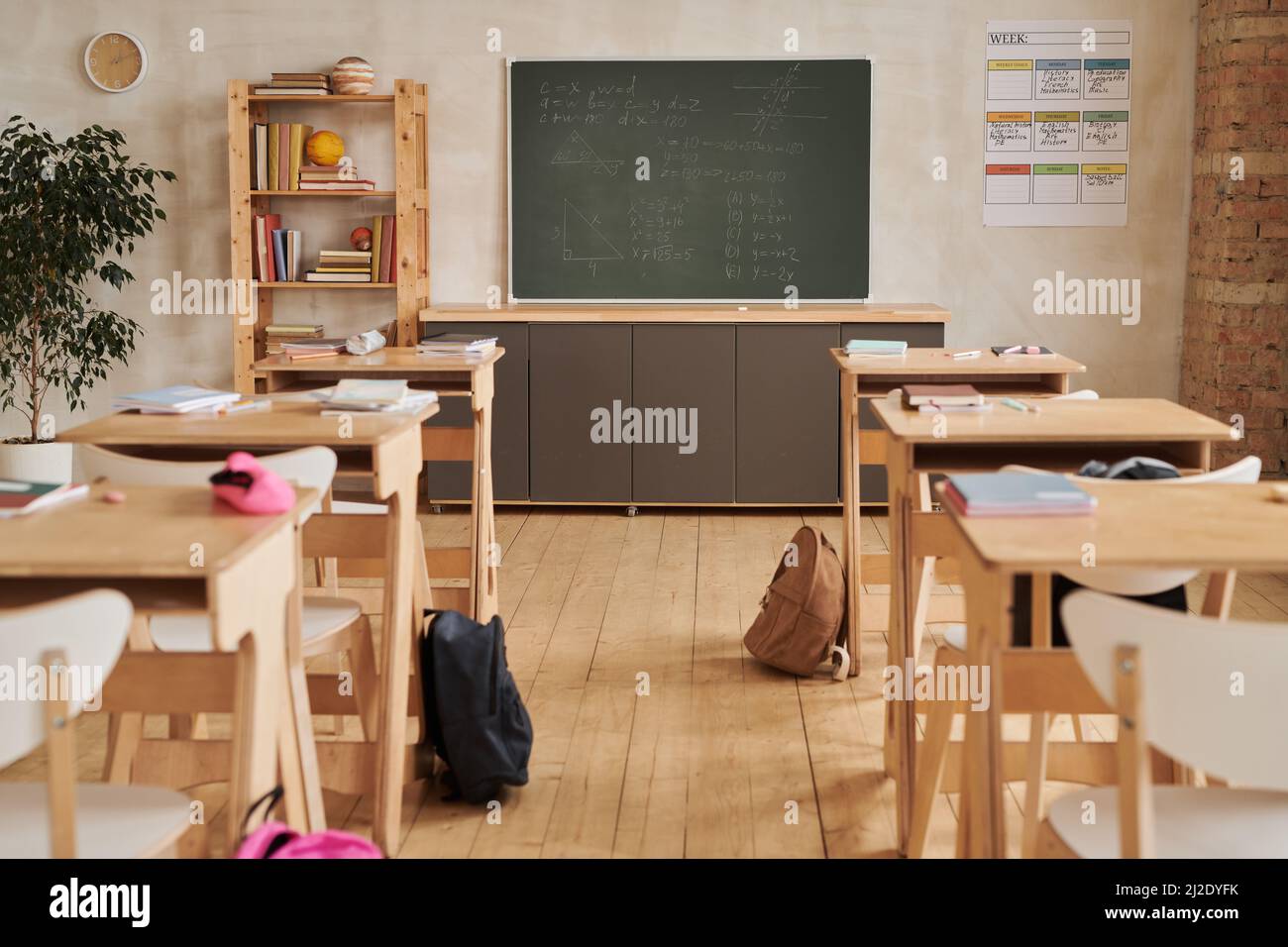Wide angle background image of wooden school desks in row facing ...