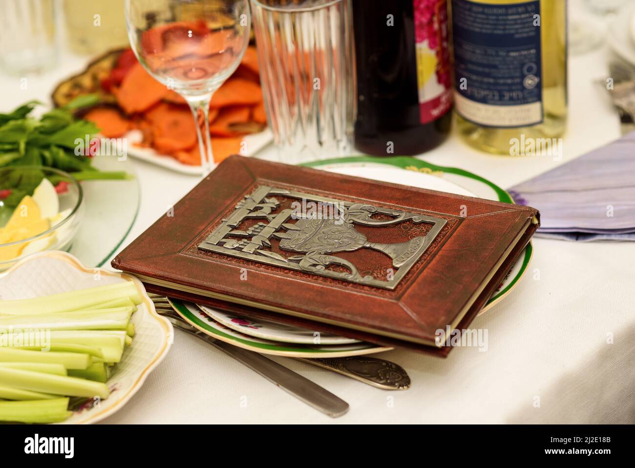 Table with Passover Haggadah and traditional food that is eaten in the ...