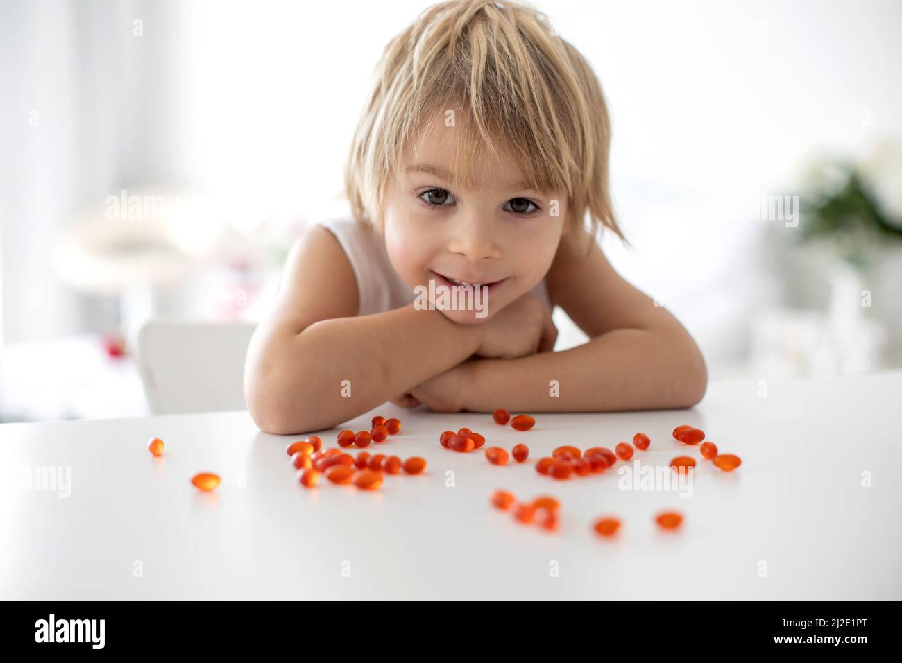 Cute little child, toddler boy, eating alfa omega 3 child suplement ...