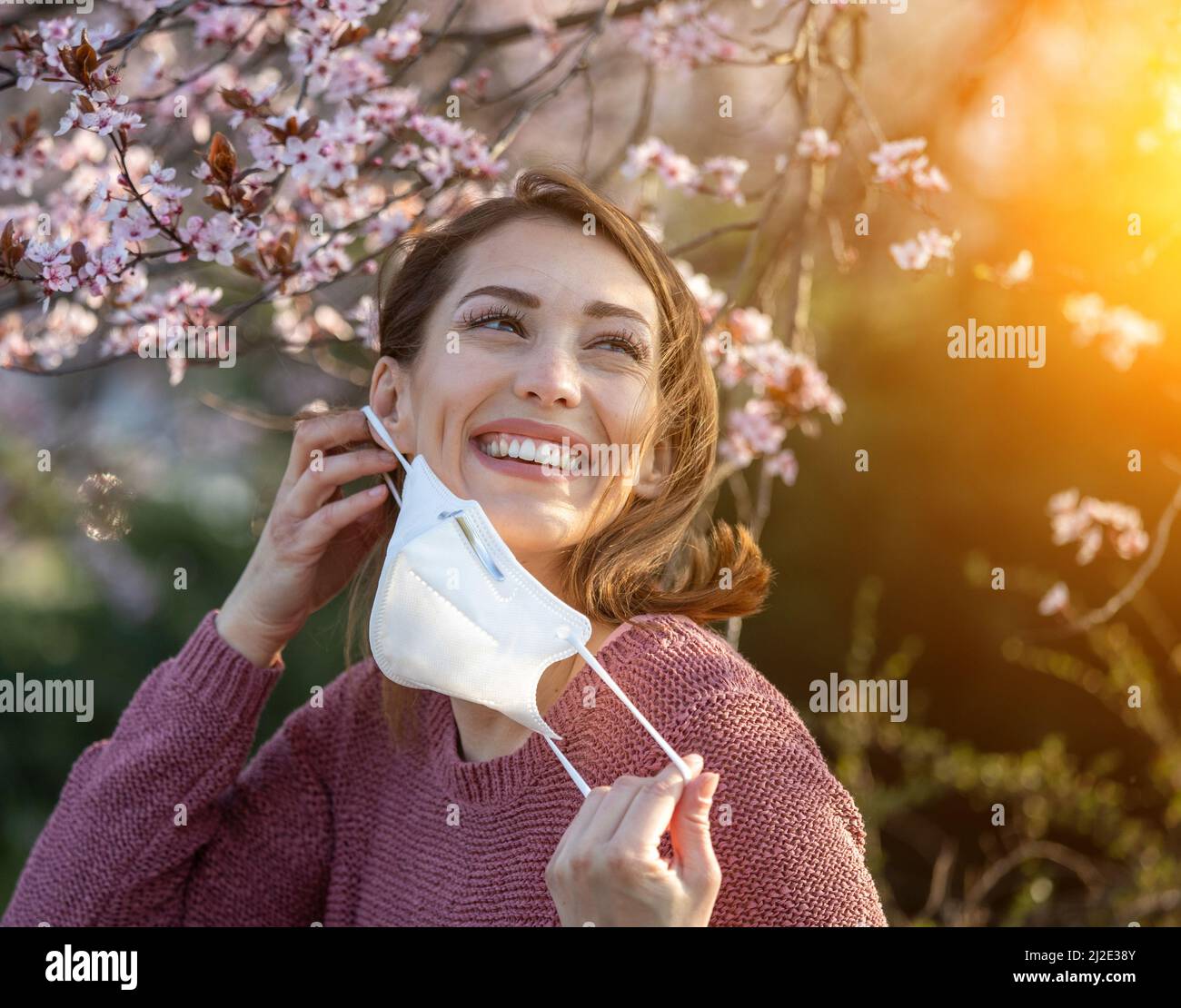 Portrait of a young smiling girl taking off her mask while she enjoys ...