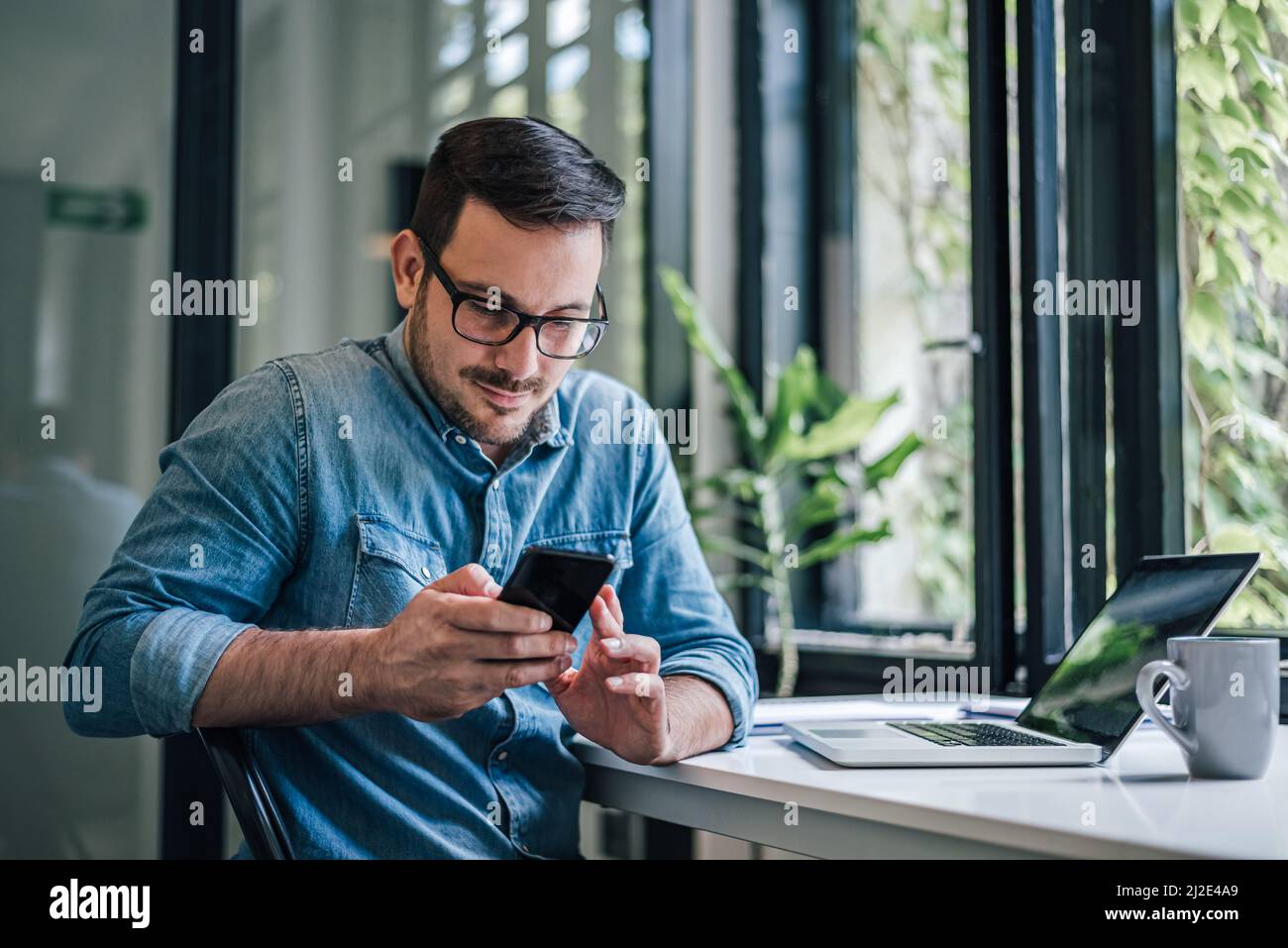 Bearded man, checking his schedule for the day, on his mobile phone ...