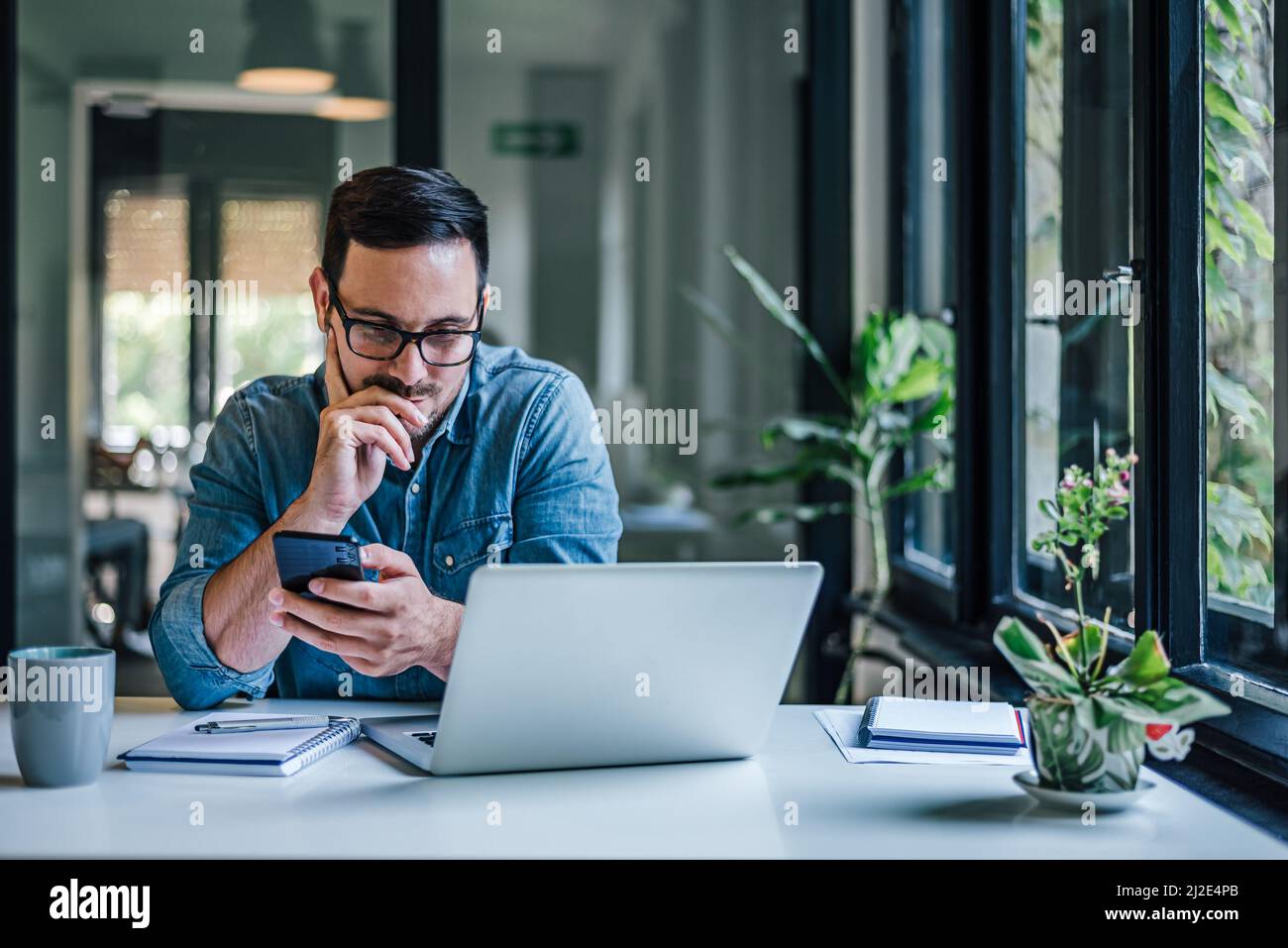 Smart adult man, working hard in the office, checking his notes Stock ...