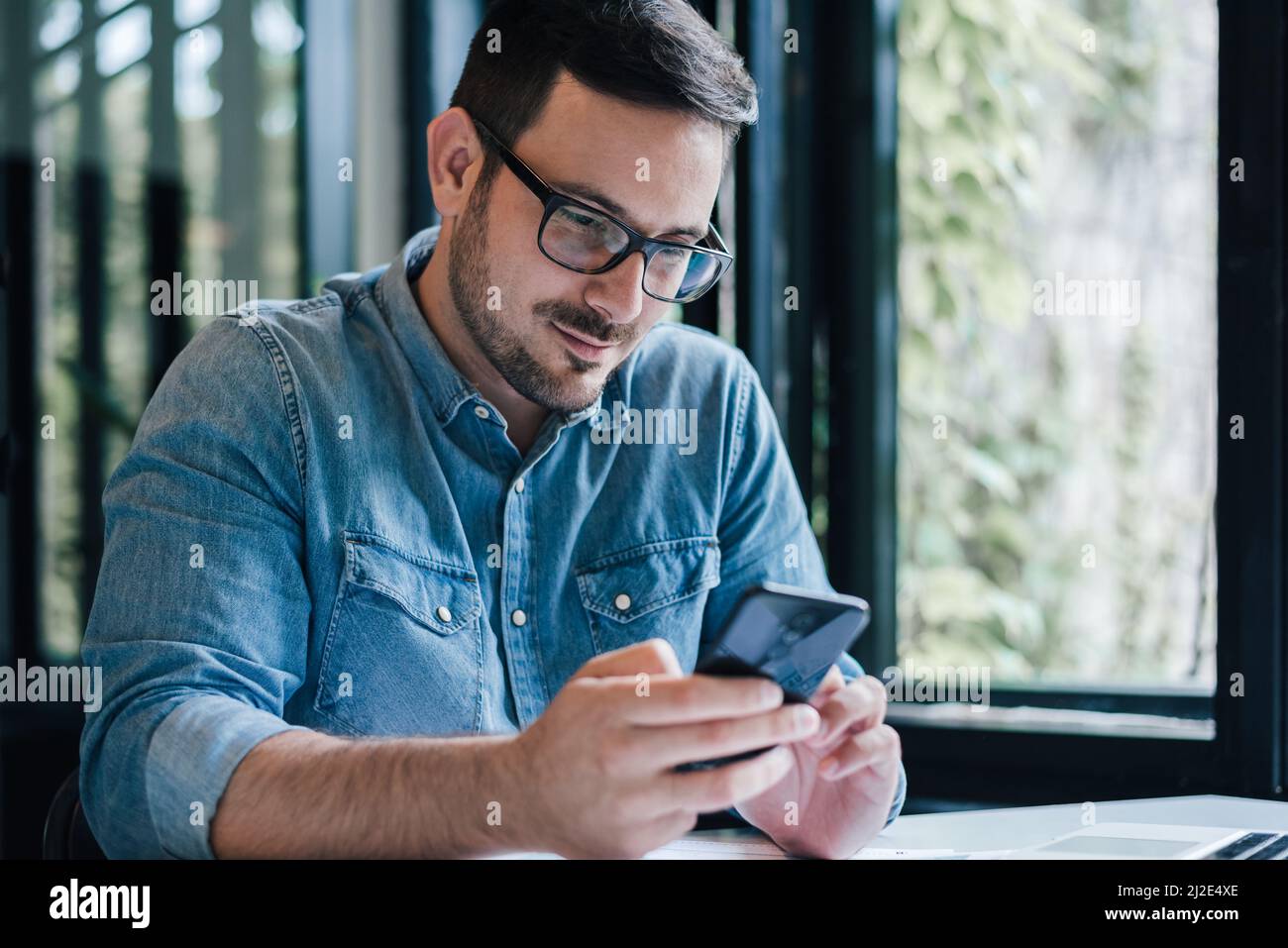 Focused adult man, typing in his password for his bank account in the ...