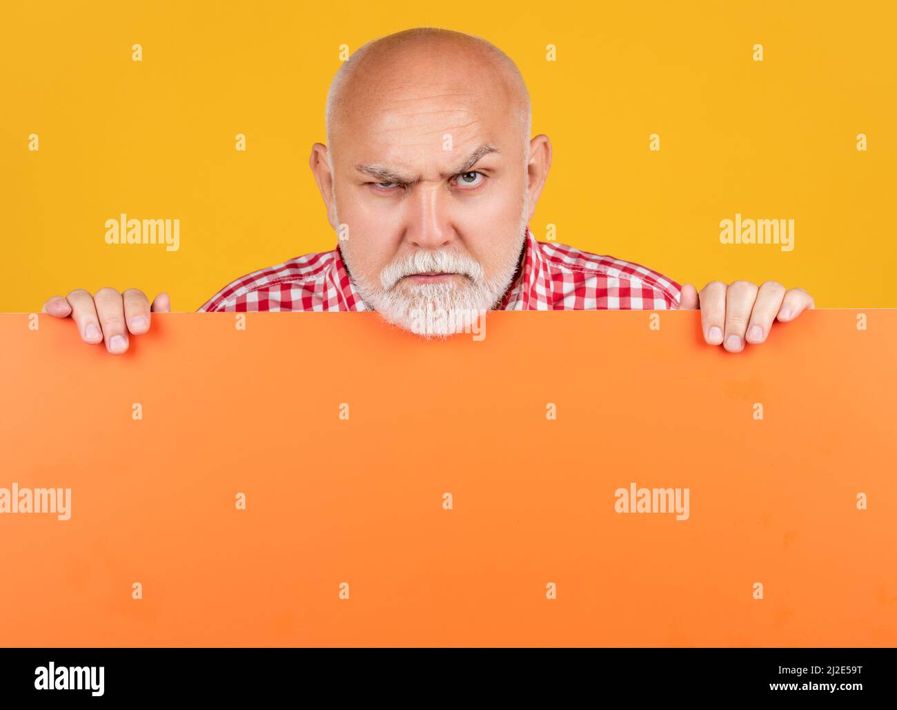 angry senior man with copy space on blank banner. presenting product ...