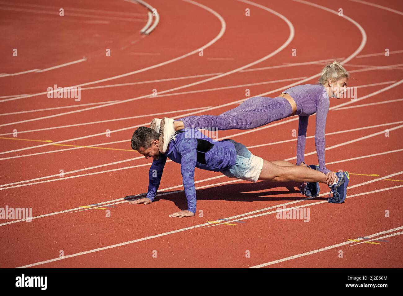pumping up muscles. athletic man and woman in stand plank. male and ...
