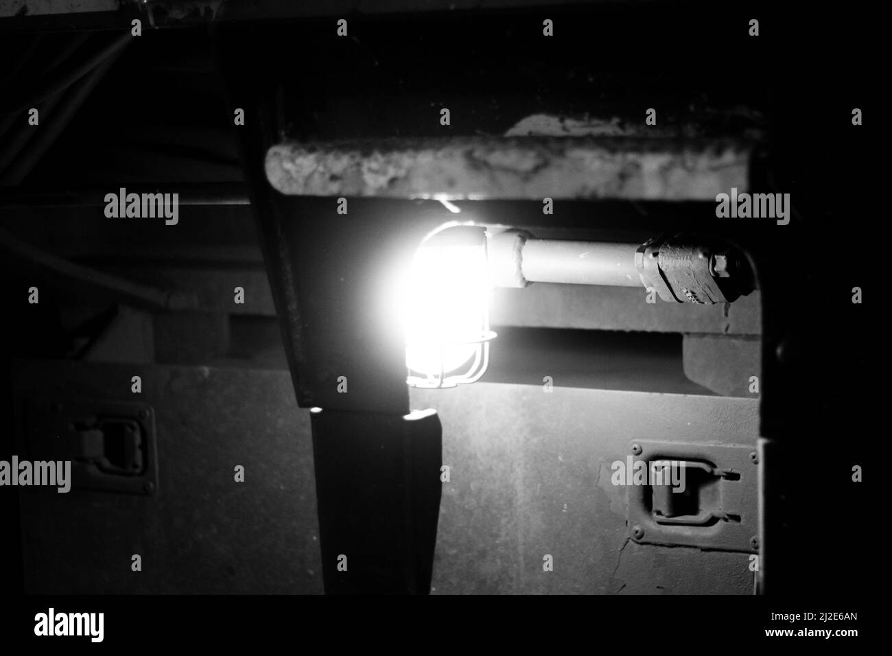 A bright light glowing while hanging in the underbelly of a train ...