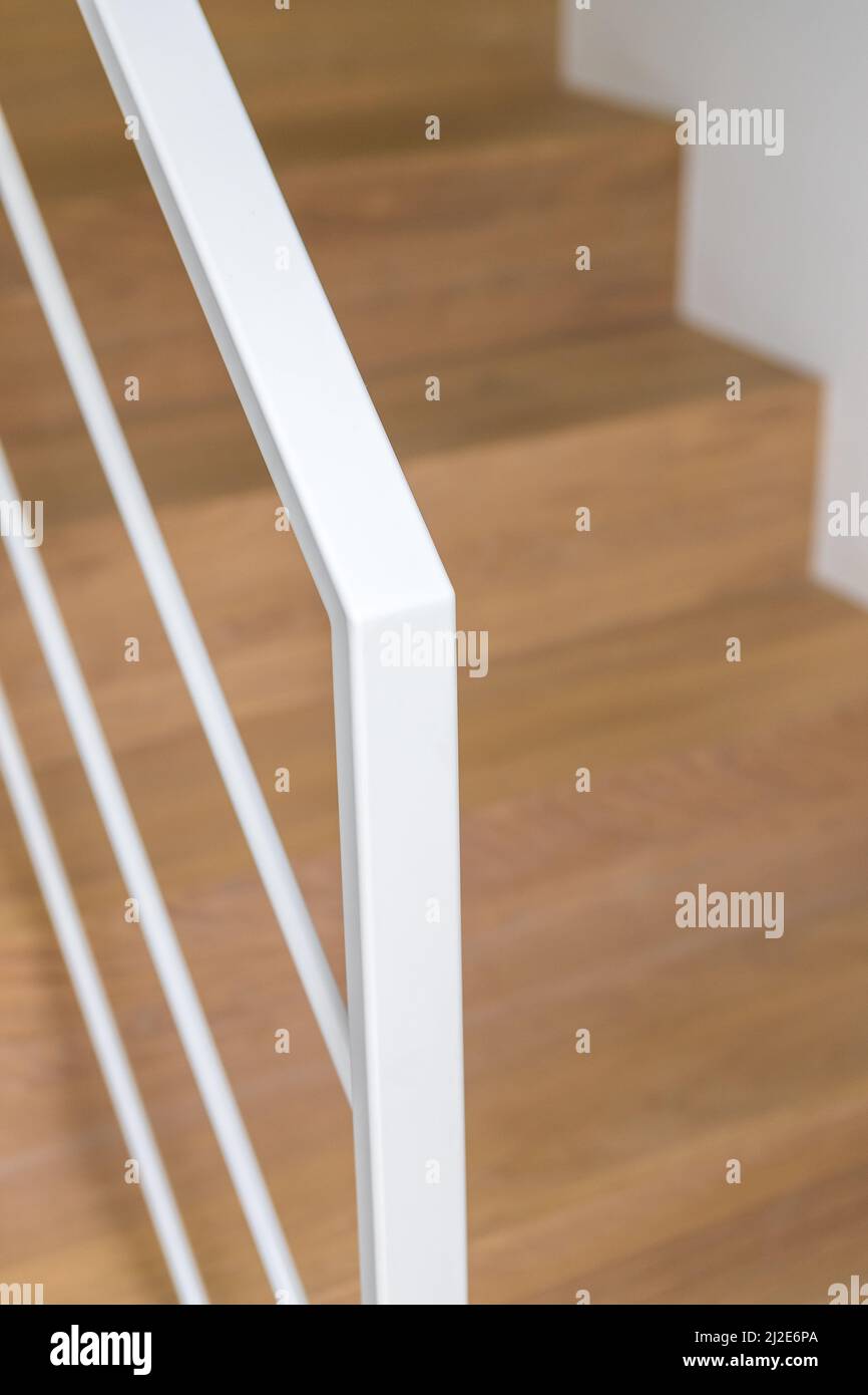 A vertical shot of wooden staircase and white handrails inside the ...