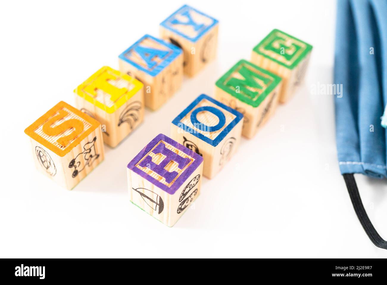 STAY HOME sign out of kids' alphabet blocks with homemade face masks on ...