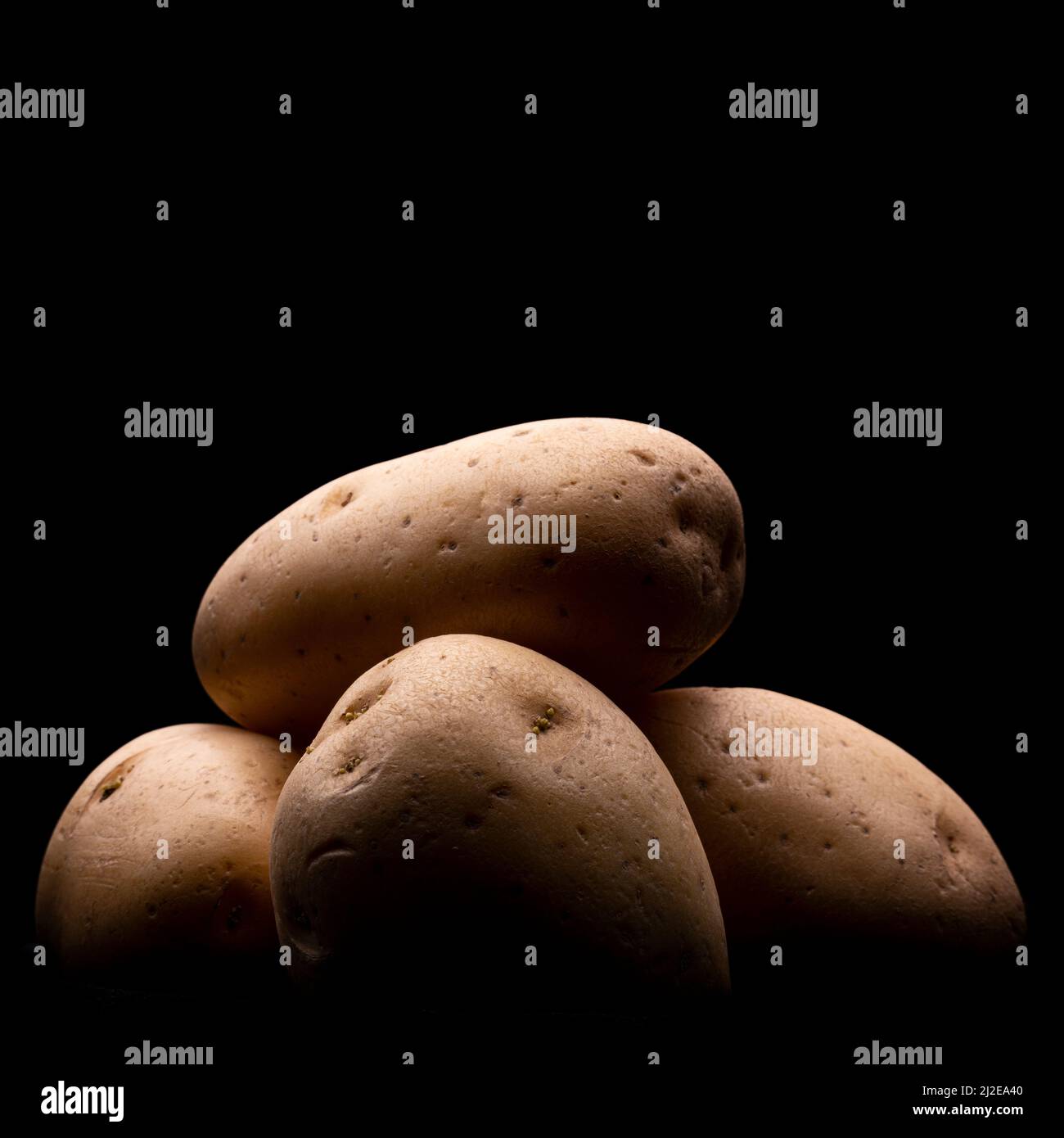 Low light macro photo of potatoes on a black background Stock Photo - Alamy