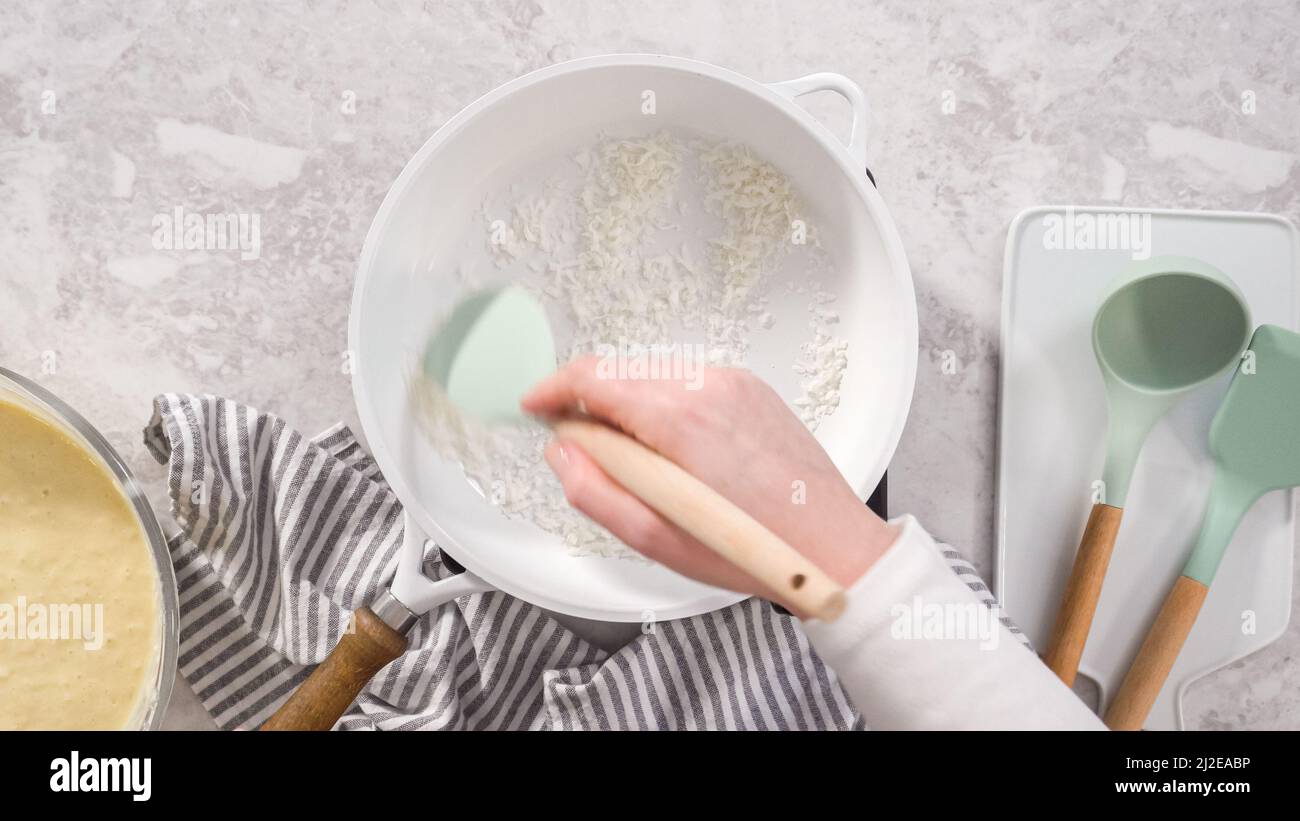 Flat lay. Step by step. Toasting coconut flakes on a nonstick white ...