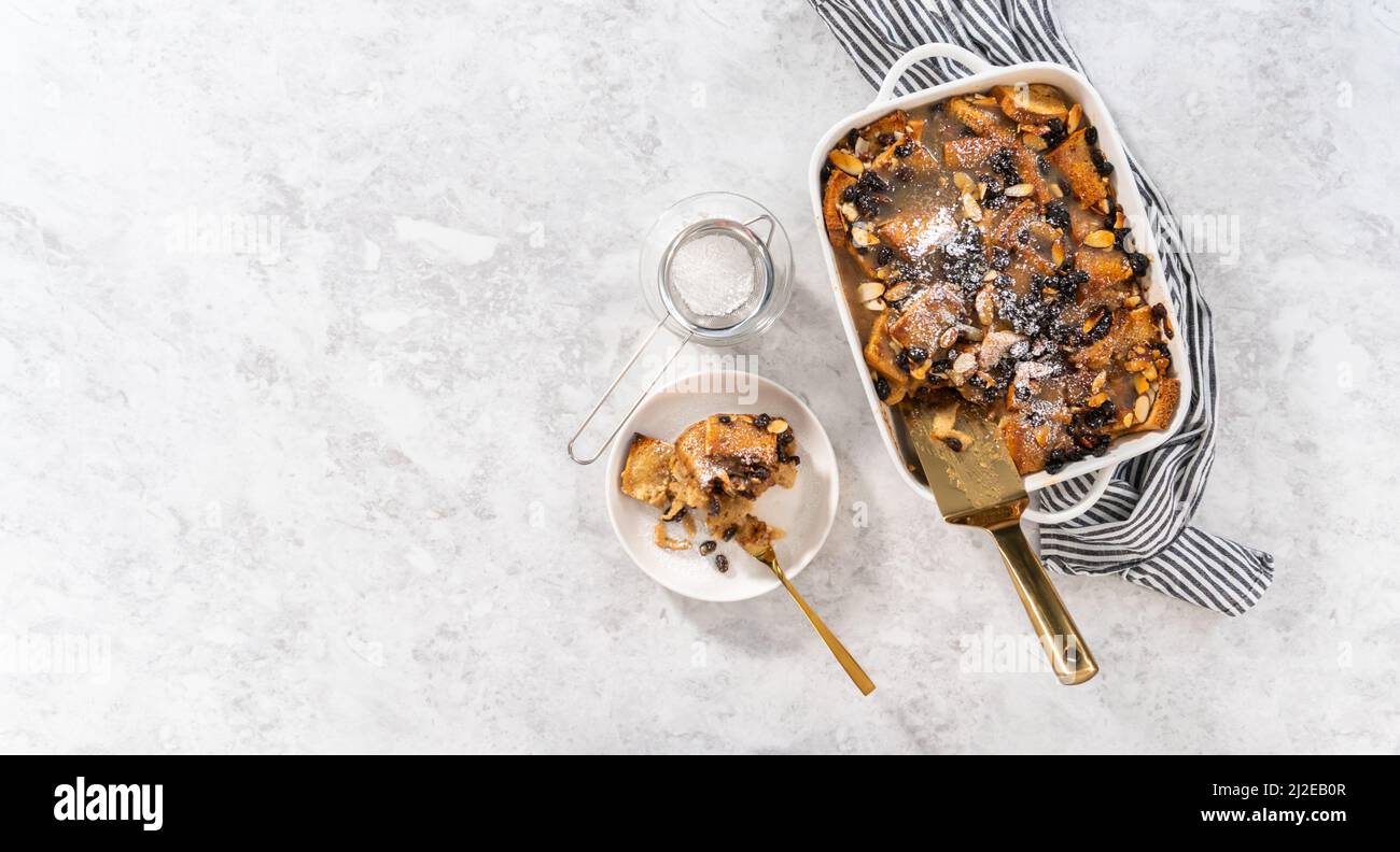 Flat lay. Serving freshly baked bread pudding with raising and almond ...