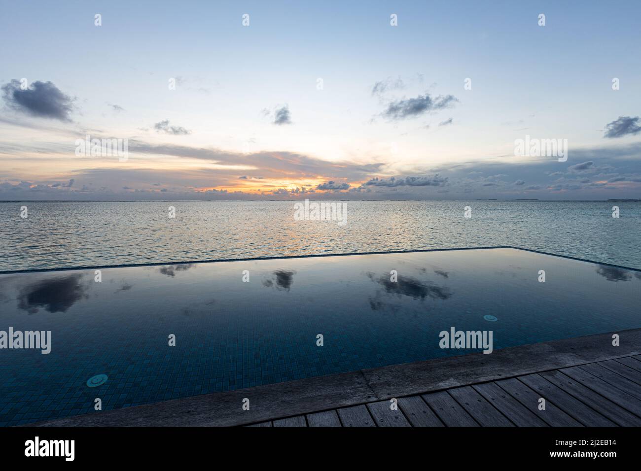 View of a infinity pool near the ocean at sunrise Stock Photo - Alamy