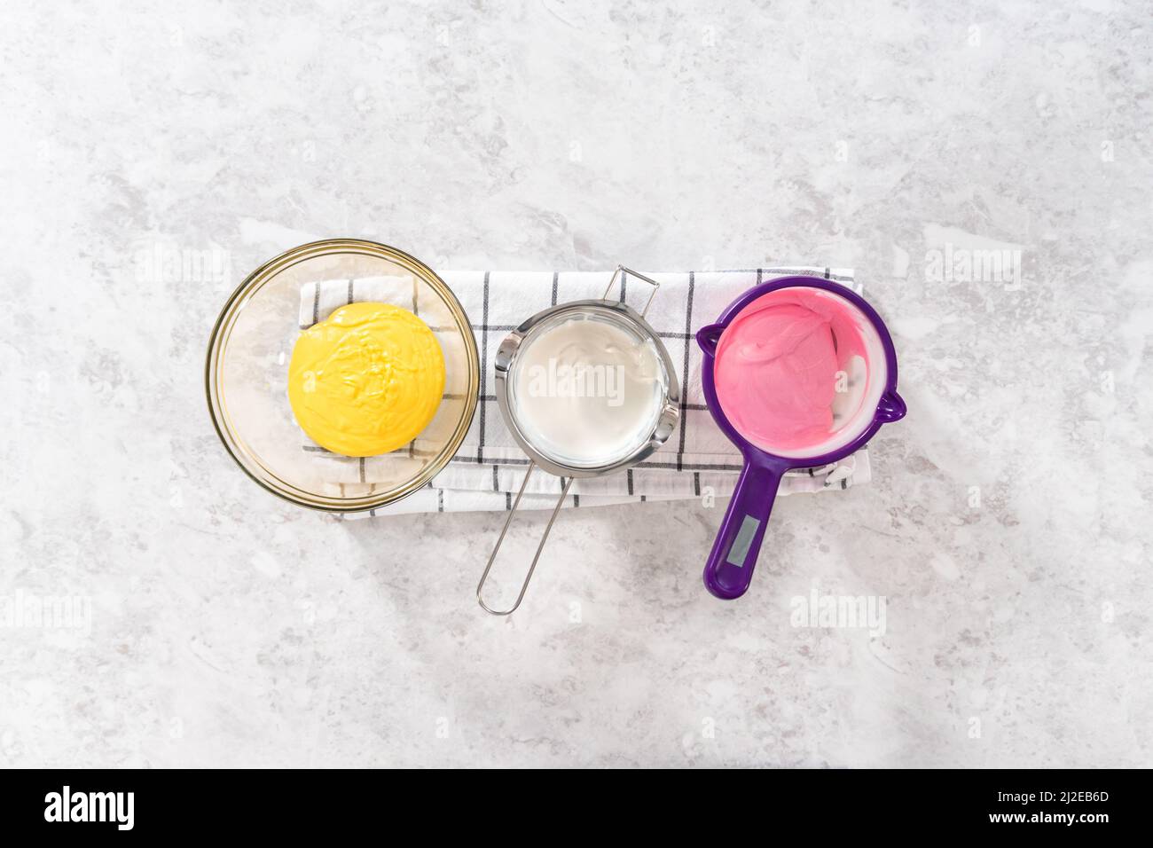 Flat lay. Melted pink, white, and yellow chocolate chips on the kitchen ...