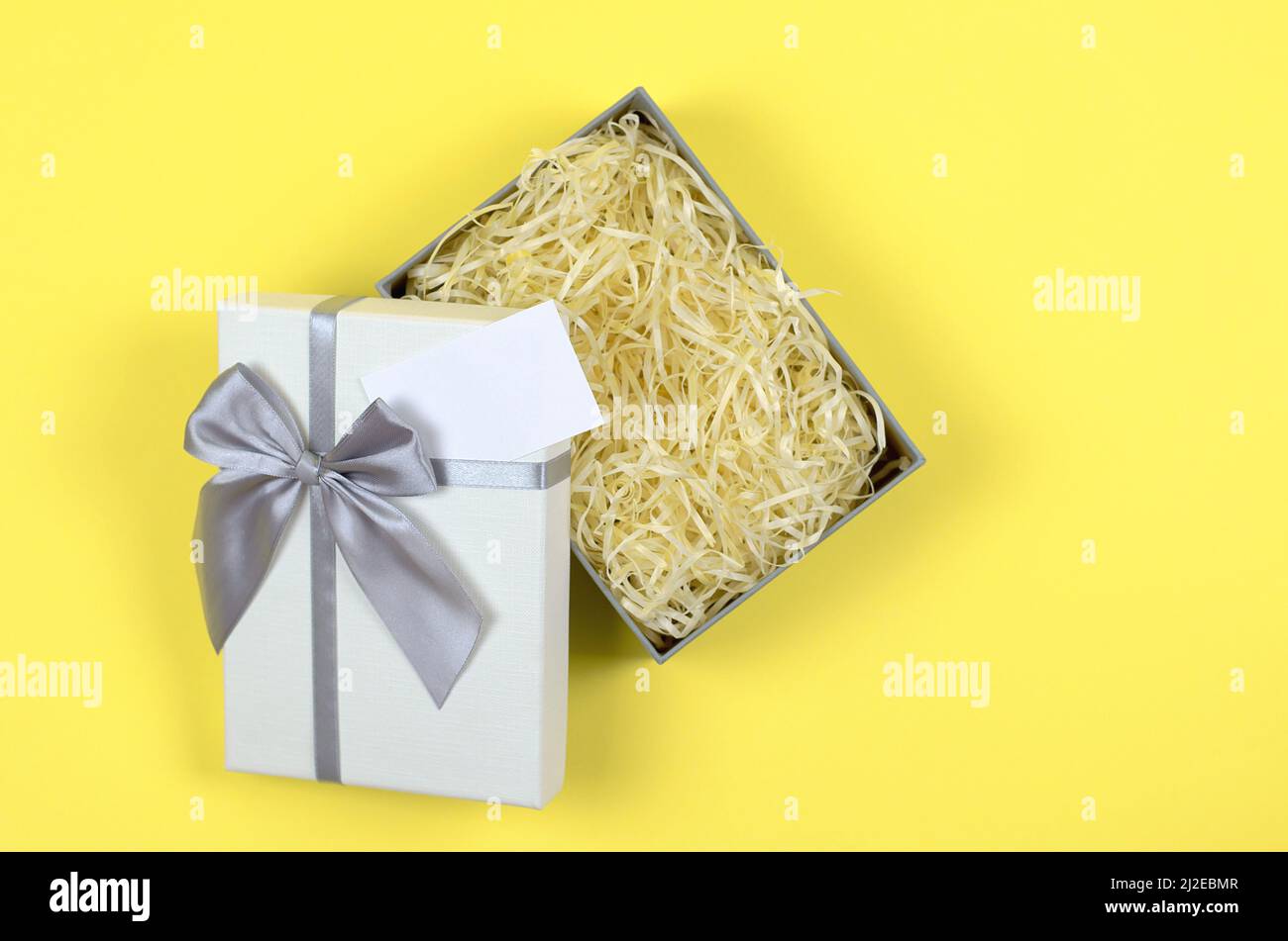 Gift box with filler on a yellow background for product advertising ...