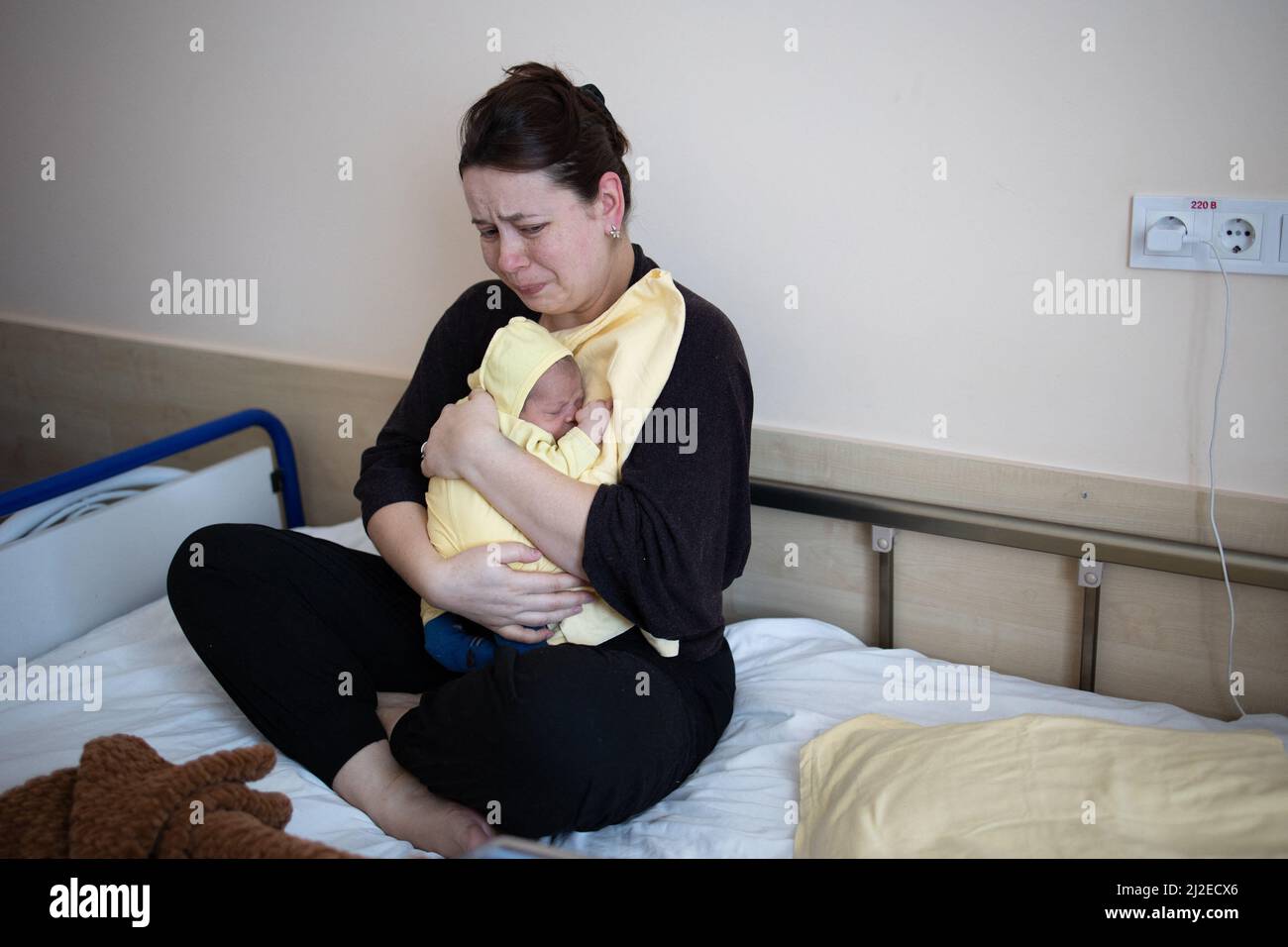 A mother cries as she hold her new born baby in the maternity of the ...
