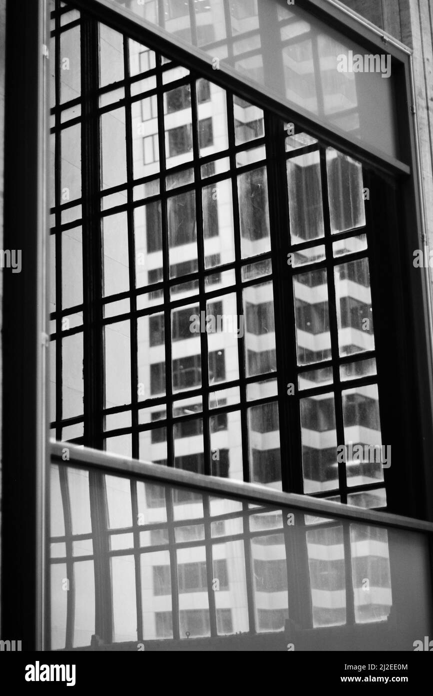 A reflection of a tall skyscraper as seen thru a huge window on another ...