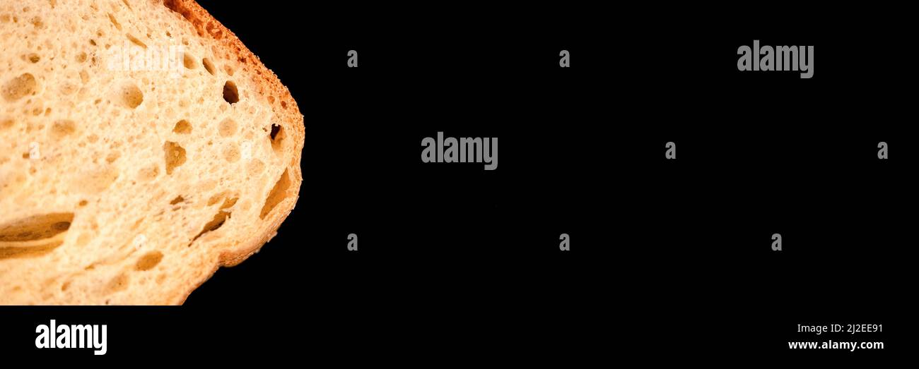slice of white bread close up isolated on a black background. rough ...